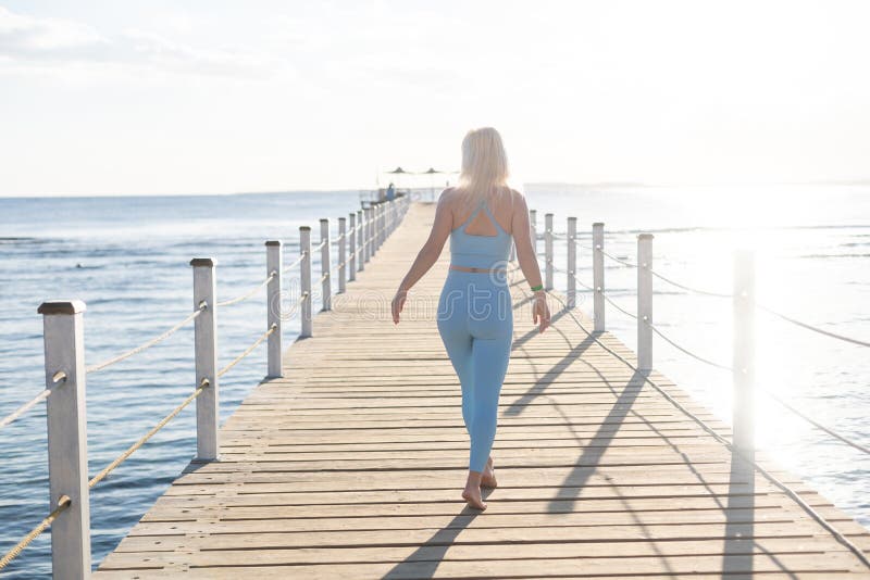 Woman Doing Yoga Exercises by the Sea. Stock Image - Image of blue ...