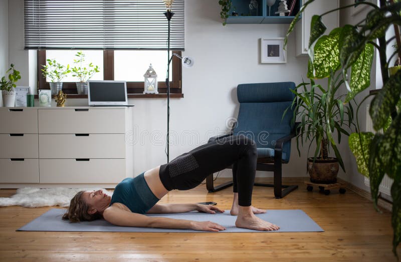 Woman doing yoga at home stock photo. Image of pose - 208188030
