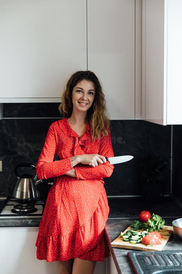 Woman in Red Dress Cooking a Romantic Dinner in the Kitchen Stock Image ...