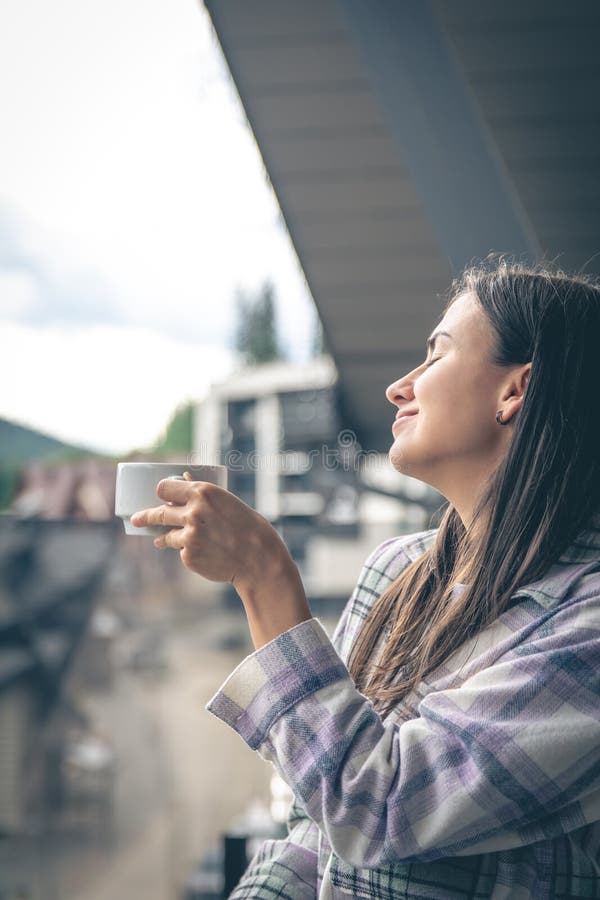 A Woman Drinking Coffee on the Balcony in the Morning. Stock Image ...