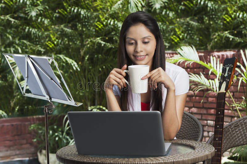 Woman Drinking Coffee and Using a Laptop Stock Image - Image of ...