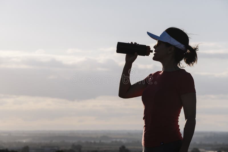 Woman Drinking Water from a Bottle Against the Light Stock Image ...
