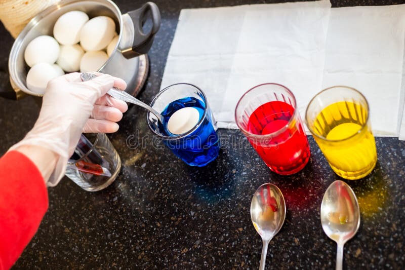 A Woman Dyes Chicken Eggs in Multi-colored Food Dyes. Preparing for the ...