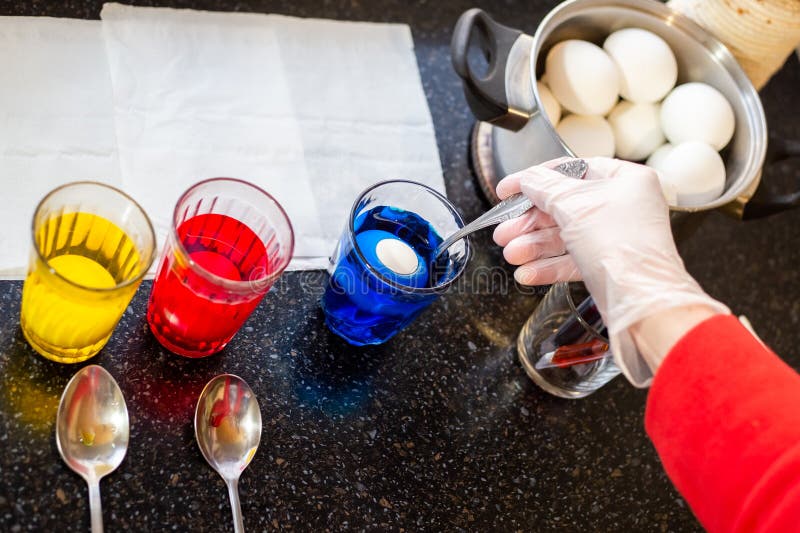 A Woman Dyes Chicken Eggs in Multi-colored Food Dyes. Preparing for the ...