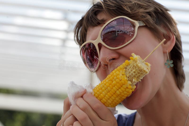 Woman eating boiled corn stock image. Image of sunglasses - 33005665