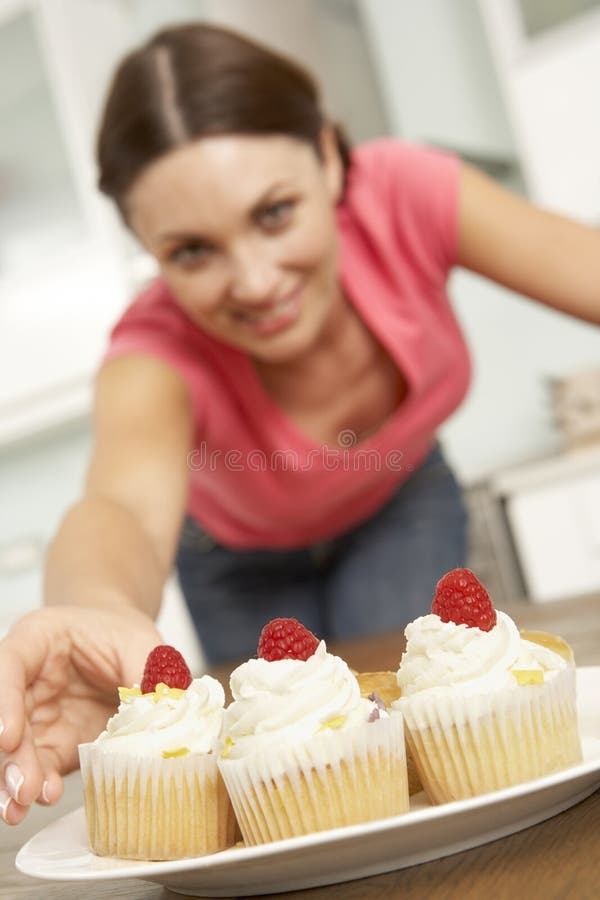 Woman Eating Cakes in Kitchen Stock Image - Image of indoors, enjoying ...