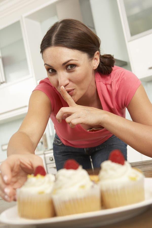 Woman Eating Cakes in Kitchen Stock Image - Image of food, smiling ...