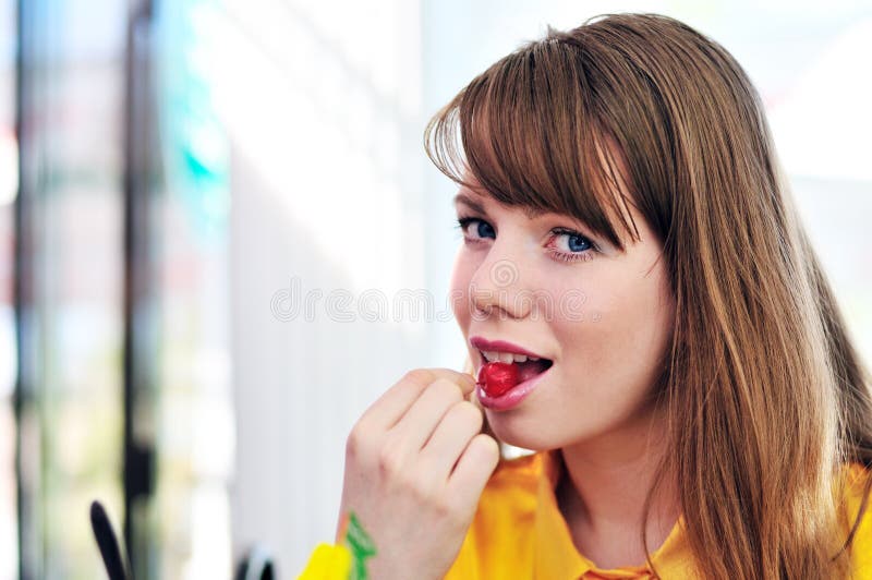 Woman eating cherry stock photo. Image of cafe, gorgeous - 14324574