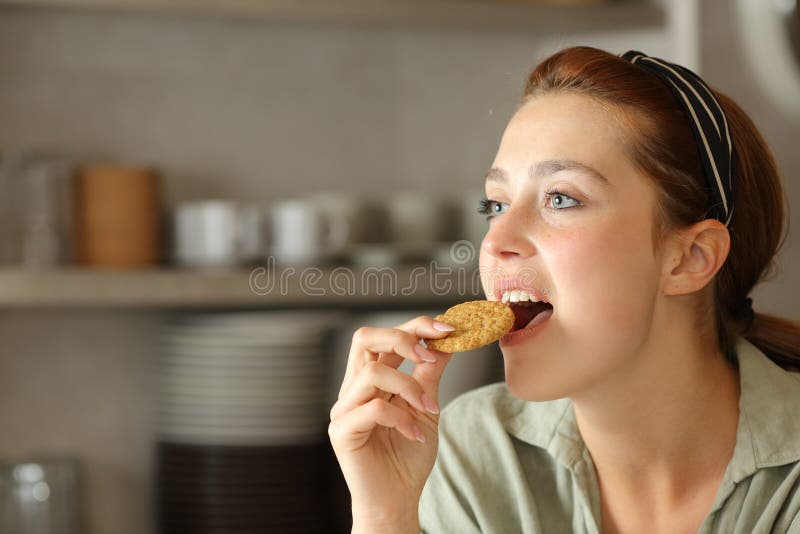 Woman Eating Cookie in the Kitchen at Home Stock Image - Image of ...