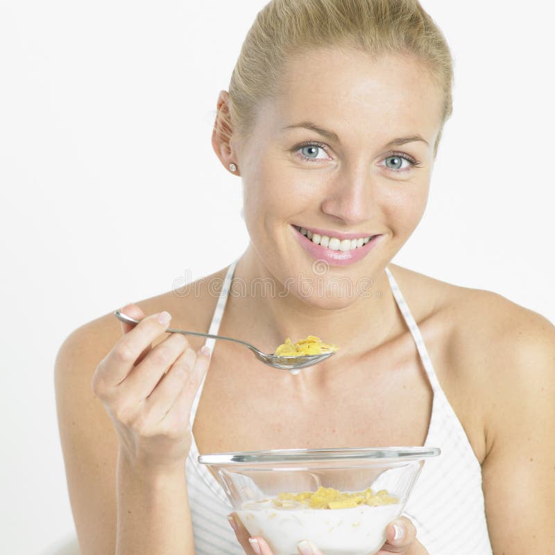 Woman eating cornflakes stock image. Image of female - 17019147