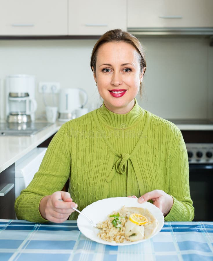 Woman eating at kitchen stock image. Image of filleted - 50725387