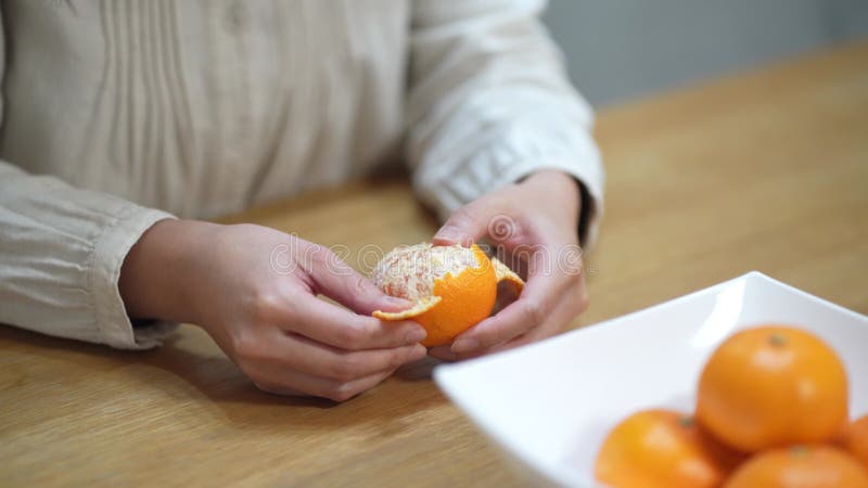 A woman eating a tangerine stock video. Video of streaks - 324773401