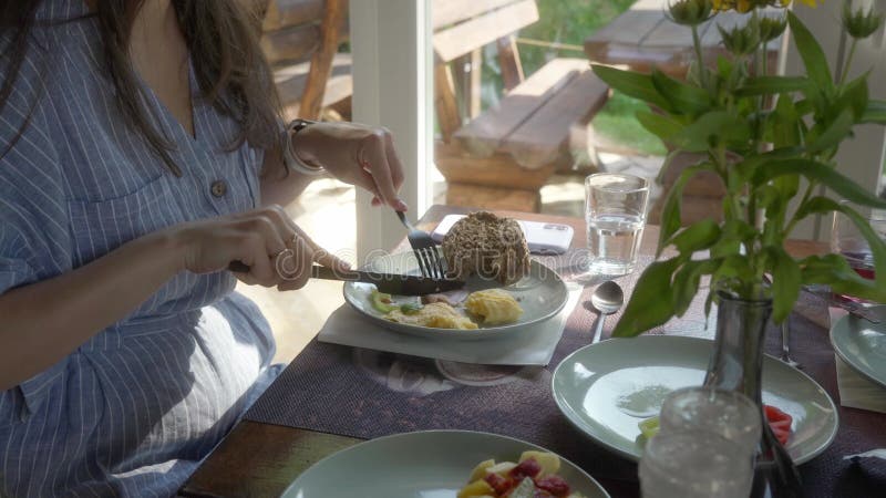 A Woman Eats Ham for Breakfast, with an Omelet, Vegetables, and Bread ...