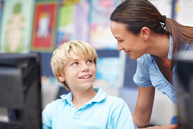 Woman, Educator and Smile with Boy on Computer in Classroom for Help, Teaching and Learning ...