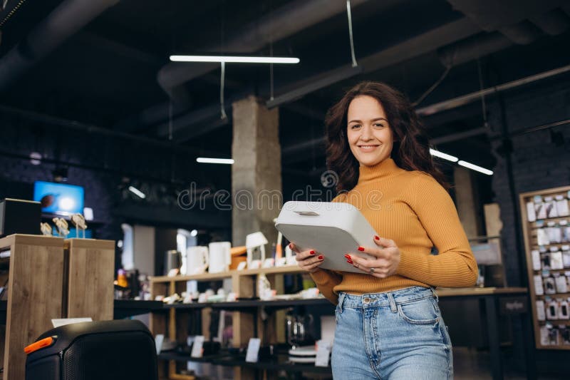 A Woman in an Electronics Store with a White Box in Her Hands. Stock ...