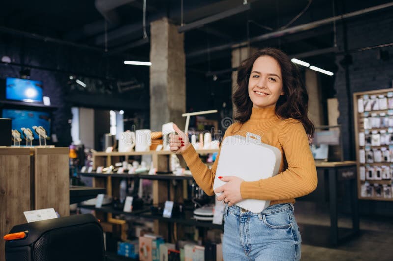 A Woman in an Electronics Store with a White Box in Her Hands. Stock ...