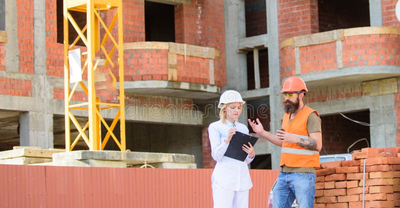 Woman Engineer and Builder Communicate at Construction Site ...