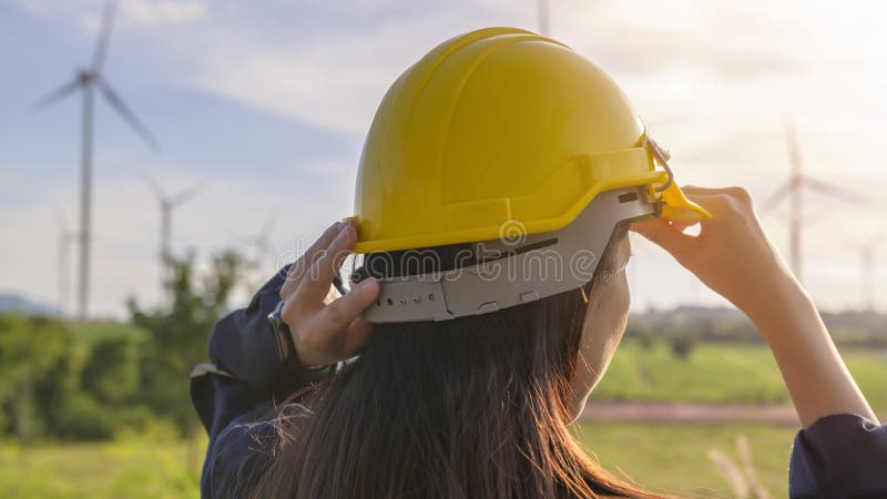 Woman Engineer is Putting a Protective Helmet on Her Head at Sunset ...