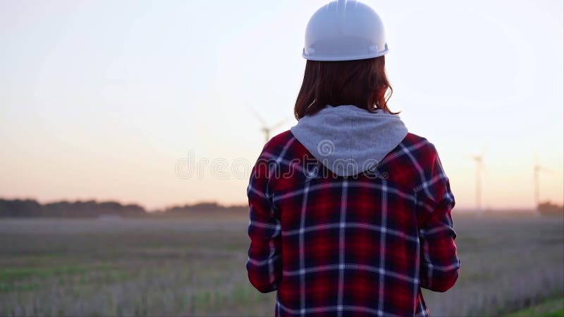 Woman Engineer Taking Notes on a Clipboard on a Field with Wind ...