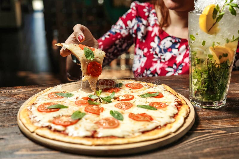 Woman Enjoying a Slice of Pizza at a Restaurant Stock Image - Image of ...