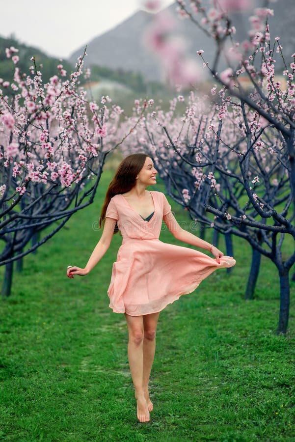 Woman Enjoying Spring in the Green Field with Blooming Trees Stock ...