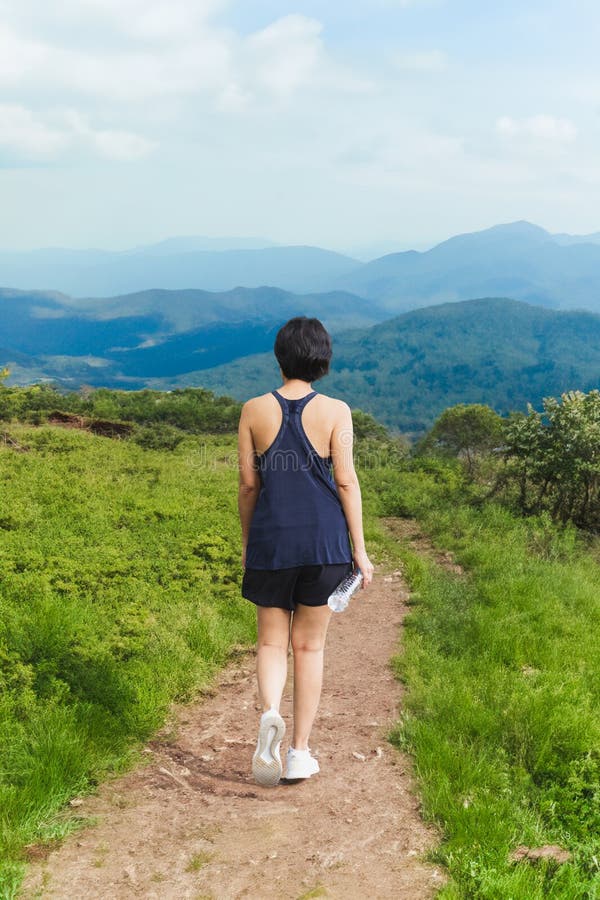 Woman Exercise Walking on Hillside Trail with Mountain View. Stock ...