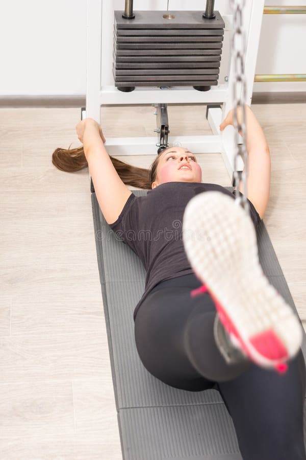 Woman Exercising Legs on Cable Machine at Gym Stock Image - Image of ...