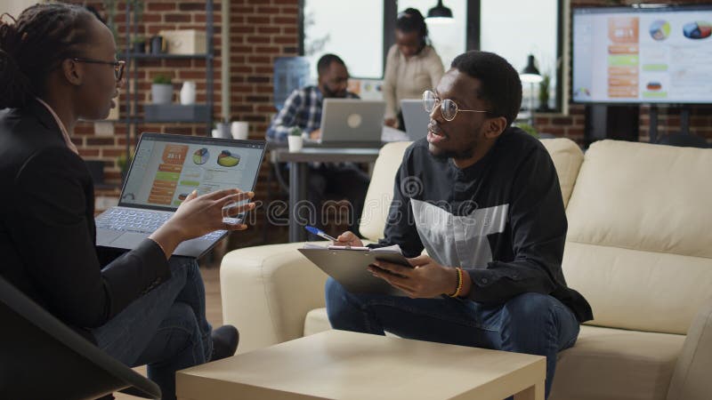 Woman Explaining Data Charts on Laptop and Man Taking Notes Stock Image ...