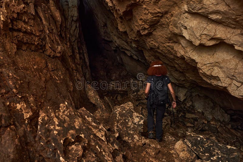 Woman explorer in a cave stock photo. Image of exploration - 252875304