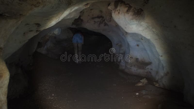 Woman Explores Stalactites Inside a Deep Dark Cave, Illuminating with ...