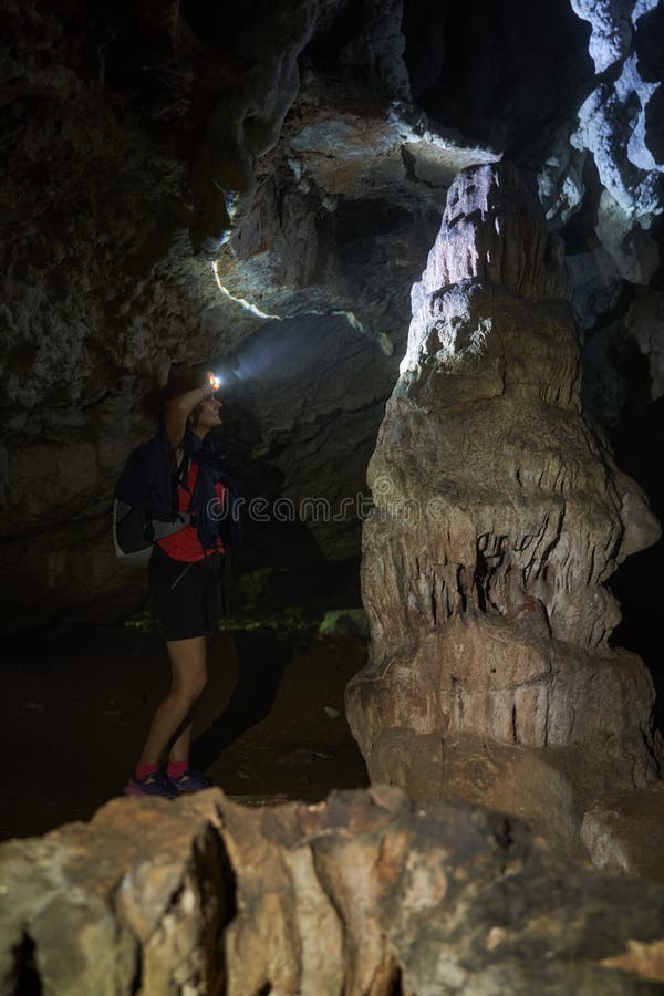 Woman exploring a cave stock photo. Image of corridor - 335954422