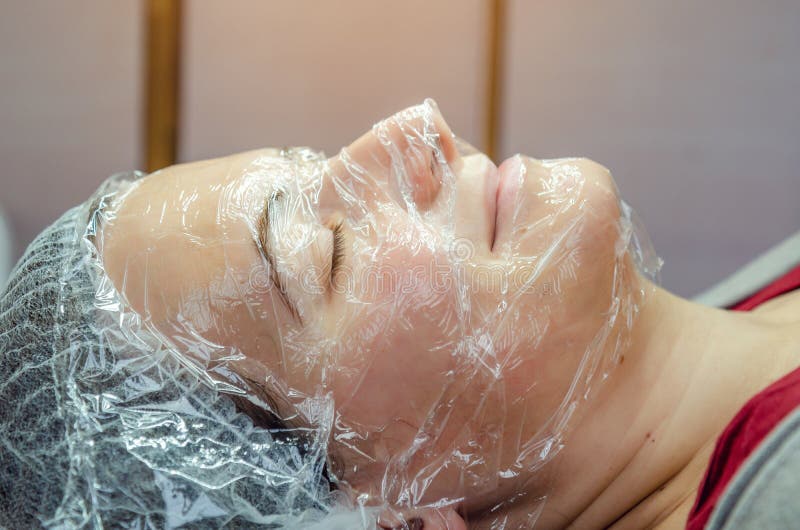 Woman Face Covered with Plastic Wrap in Beauty Salon Stock Photo ...
