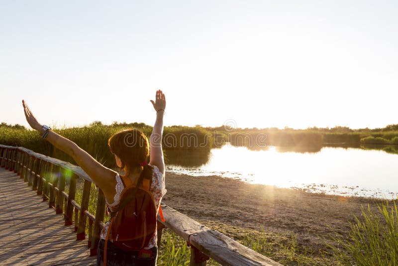 Woman facing the sunset stock photo. Image of backpack - 76538458
