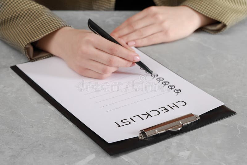 Woman Filling Checklist at Grey Marble Table, Closeup Stock Photo ...