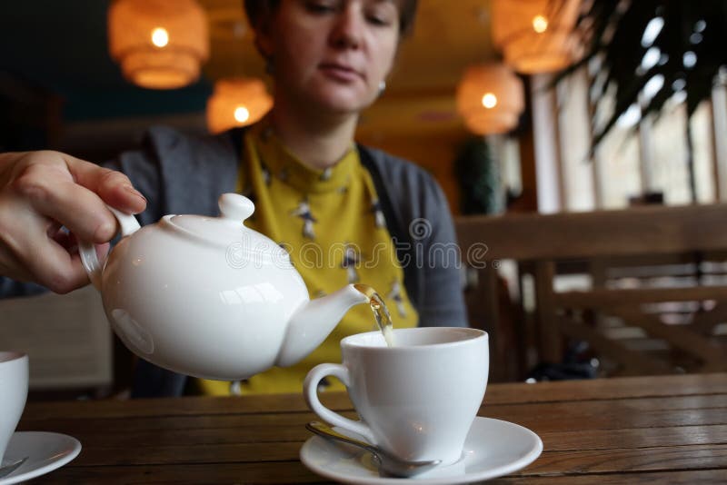 Woman filling cup of tea stock photo. Image of cafe - 113915396