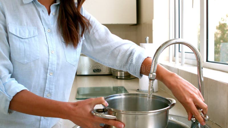 A Woman is Filling Eclairs with Cream and Placing Them on a Plate ...