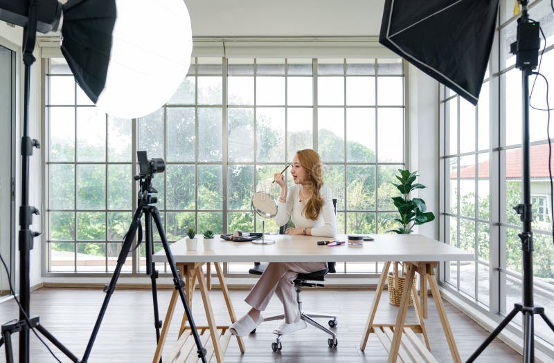 A Woman Filming Her Makeup Tutorial in a Bright Room with Large Window ...