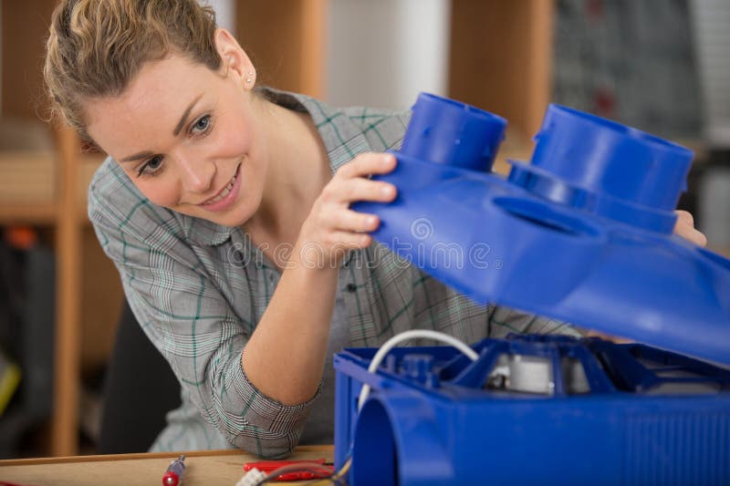 Woman fixing blue box stock image. Image of equipment - 279541541