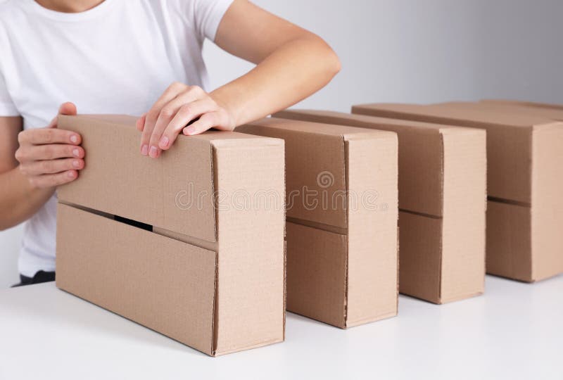 Woman Folding Cardboard Boxes at White Table, Closeup. Production Line ...