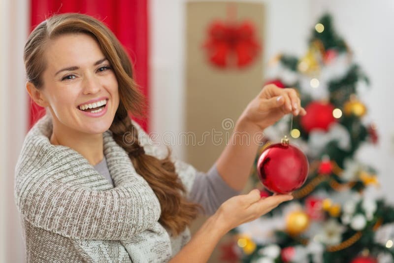 Woman in Front of Christmas Tree Holding Ball Stock Image - Image of ...