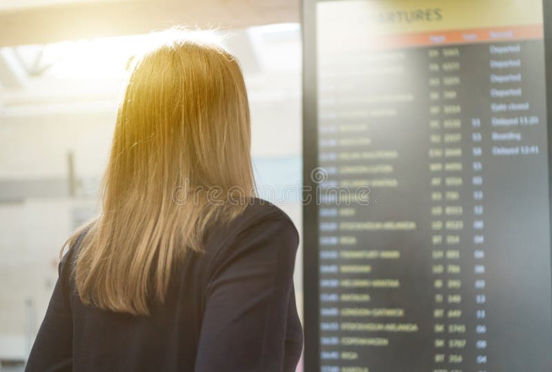 Woman checking her flight. stock image. Image of flight - 147642551
