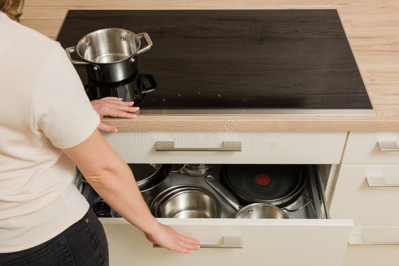 Woman in Front of Modern Cooker with Open Drawer Under the Stove Stock ...