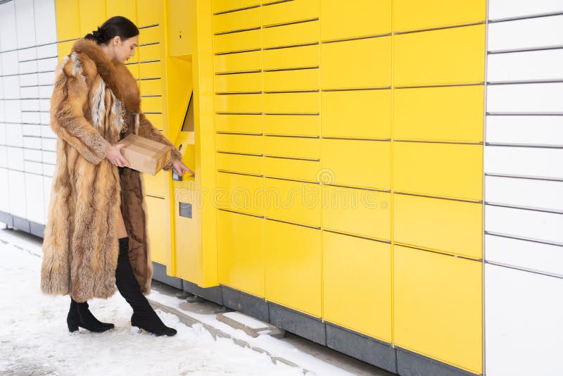 A Woman in a Fur Coat Types the Code on the Numeric Keypad of a Parcel ...