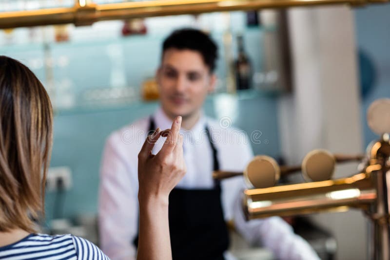 Woman Gesturing while Talking with Bartender Stock Image - Image of ...