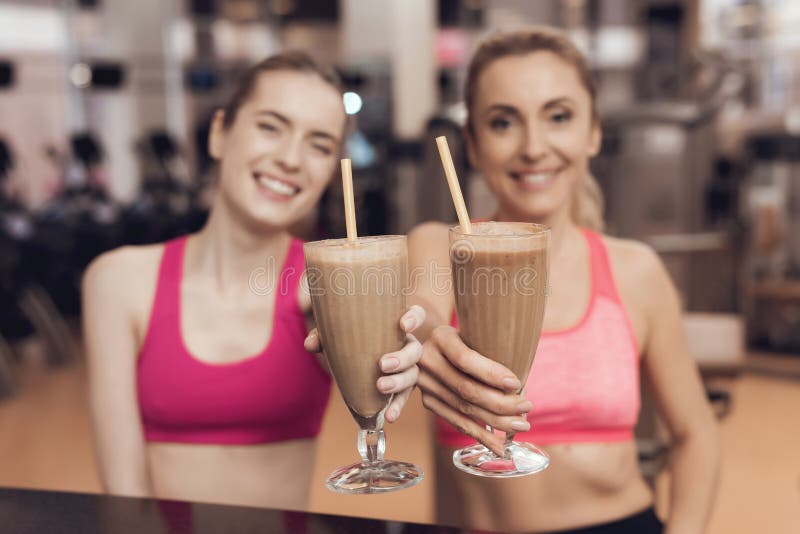 Mother And Daughter Drinking Protein Shakes At Gym They Look Happy