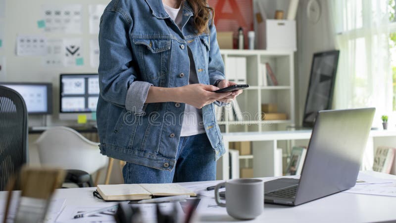 Woman Graphic Designer Using Smartphone while Working in Office. Stock ...