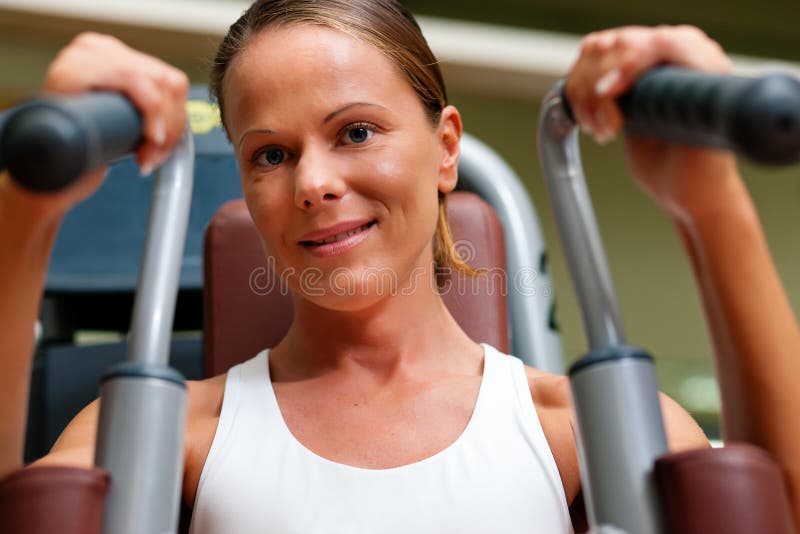 Woman in Gym on Machine Exercising Stock Image - Image of powerful ...
