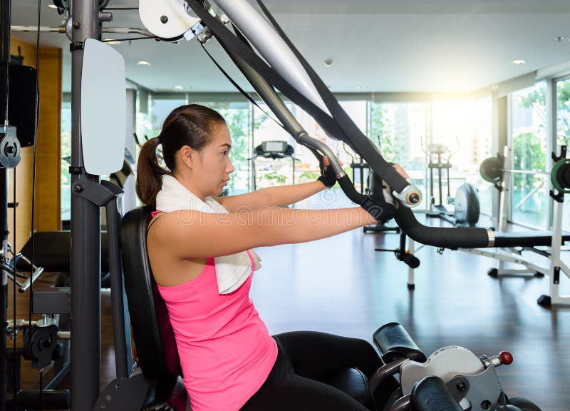 Woman at the Gym Working Out on a Machine Stock Photo - Image of ...