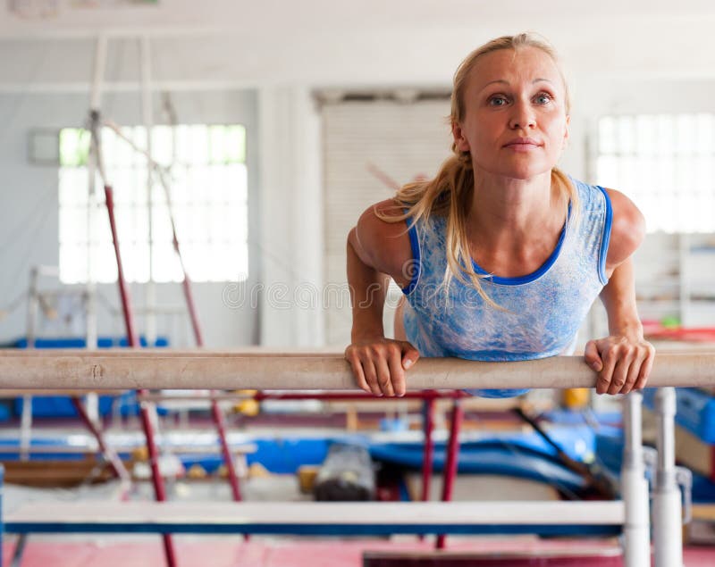 Woman Gymnast Performs Complex Acrobatic Exercise on Parallel Bars in ...