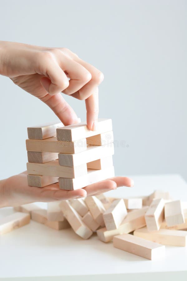 Woman Hand Constructing a Tower of Wooden Blocks on a White Background ...